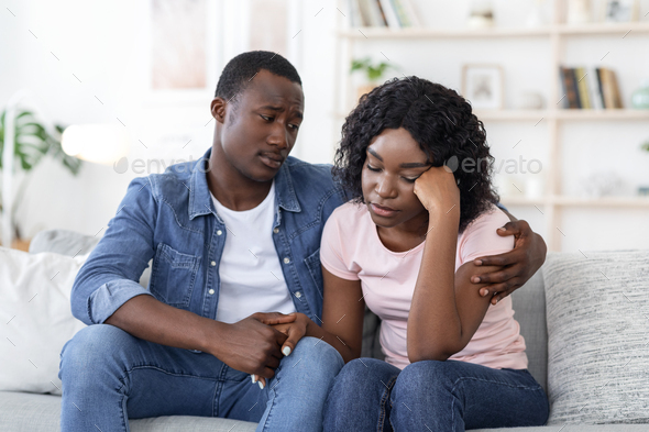 African husband comforting his crying woman, home interior Stock Photo ...