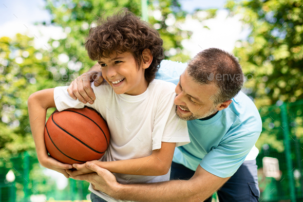 Joyful dad playing basketball with his son outdoors Stock Photo by ...