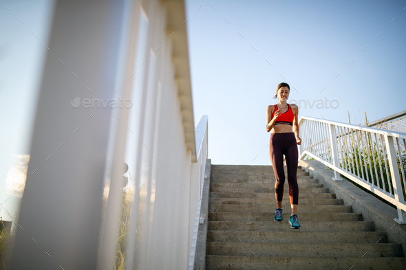 Beautiful fit female runner jogging during outdoor workout Stock Photo ...