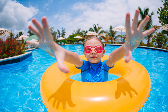 Little smile girl in outdoor swimming pool Stock Photo by travnikovstudio