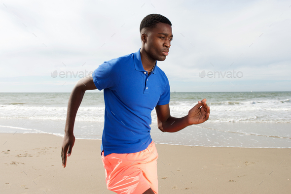 active young black man running at beach Stock Photo by mimagephotography