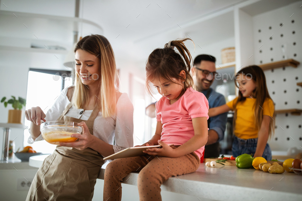 Overjoyed young family with kids having fun, cooking at home together ...