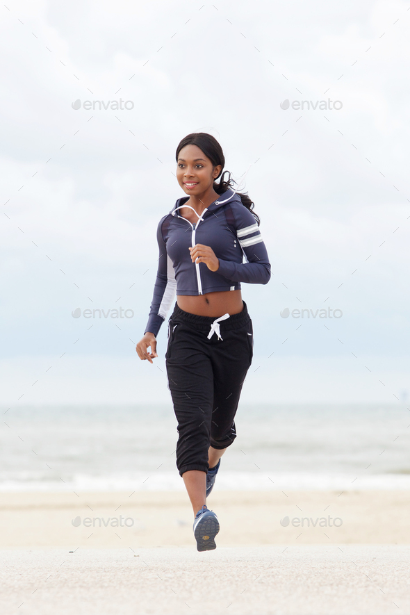 front portrait of healthy young black woman running at the beach Stock ...