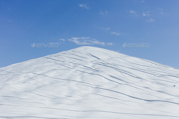 Manure heap covered with white tarpaulin, against a blue sky. Stock ...