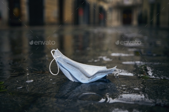 Used face mask in puddle during rain Stock Photo by Chalabala | PhotoDune