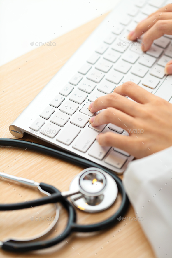 Doctor typing on keyboard with stethoscope Stock Photo by leungchopan