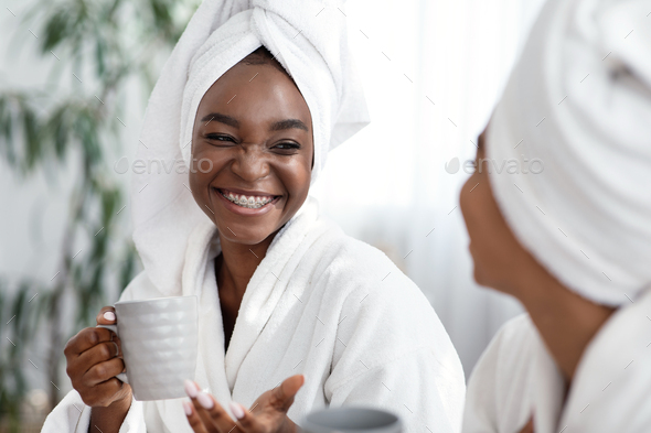 Two young african women joking while drinking tea Stock Photo by ...