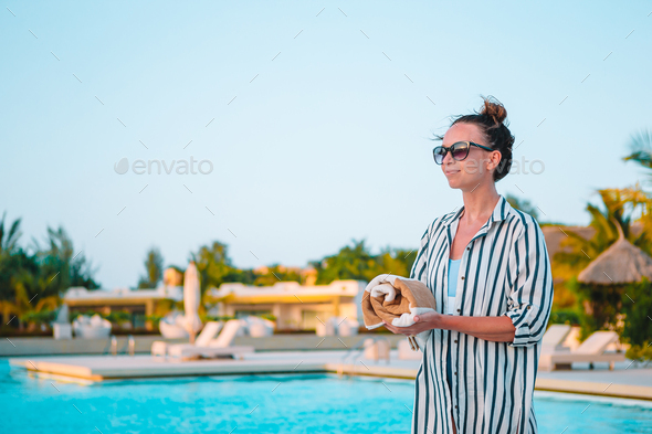 Young beautiful woman enjoying summer vacation in luxury swimming pool ...