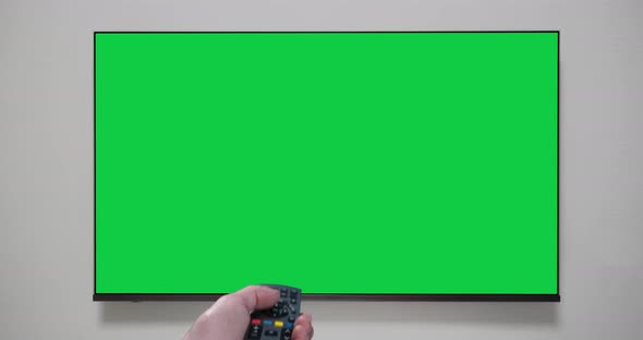 4K - Hand with remote control changes channels tv. Green screen. Chroma ...