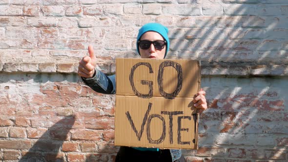 Woman shows cardboard Go Vote sign Voting balloting polling Political ...