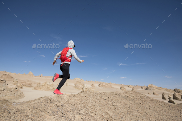 RunningWoman trail runner cross country running on sand desert dunes ...
