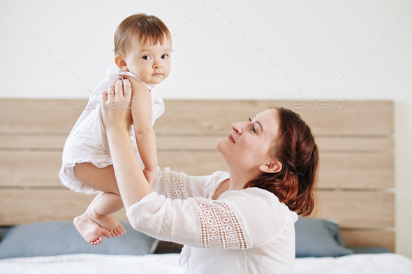 Mother lifting baby Stock Photo by DragonImages | PhotoDune