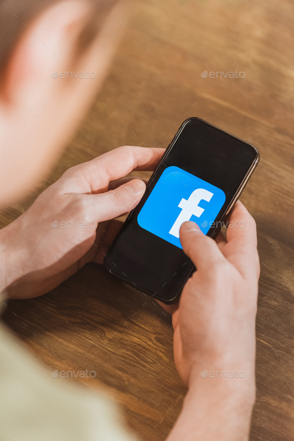 Man using smartphone with facebook logo icon on screen Stock Photo by ...