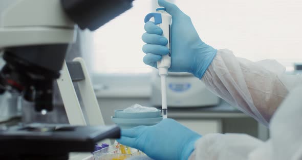 A Scientist in Sterile Clothing Looks Through a Microscope, Stock Footage