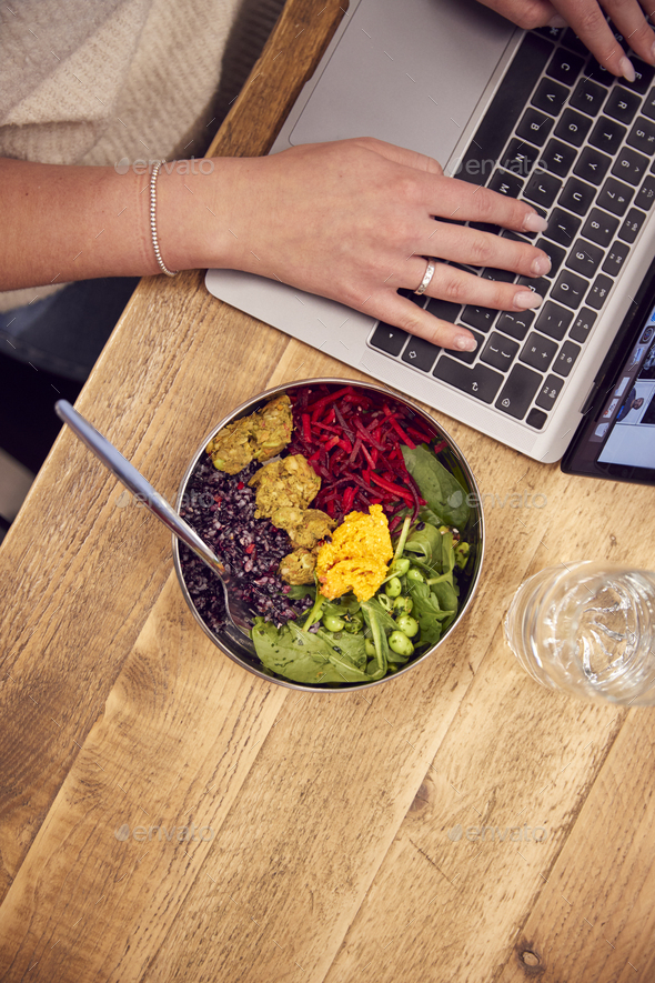 Close Up Businesswoman Working On Laptop Whilst Eating Vegan Lunch At ...