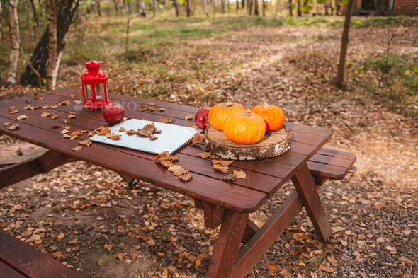Orange pumpkin and leaves near laptop computer on a table. Wooden ...