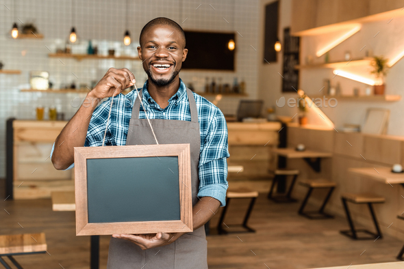 smiling male african american owner of coffee shop holding little empty ...