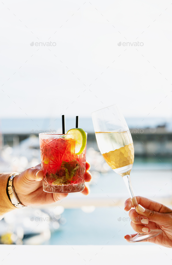 Man and woman cheering with cocktail and wine glasses Stock Photo by ...
