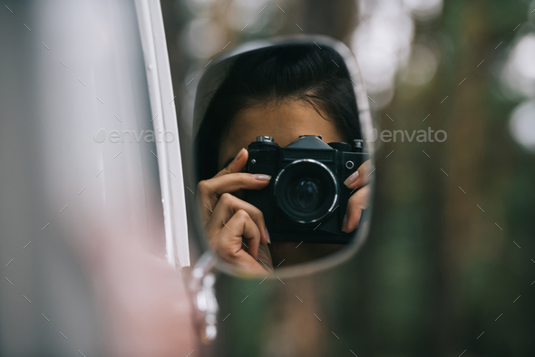young girl taking photo on camera through mirror of retro minivan Stock ...
