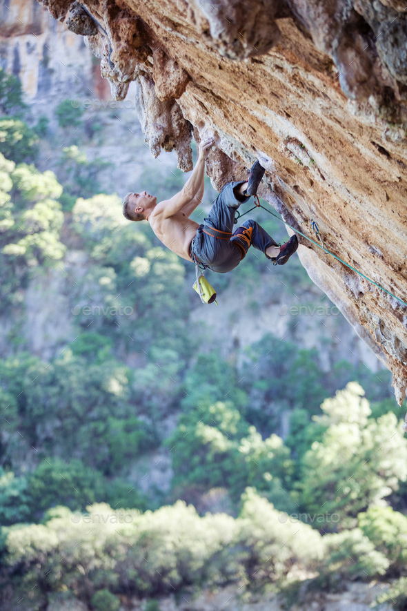 Rock climber looking up on challenging route on overhanging cliff Stock ...