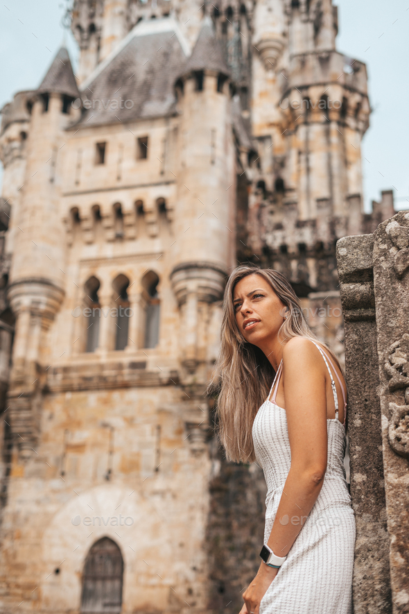 Young woman in front of a medieval castle Stock Photo by rubenchase