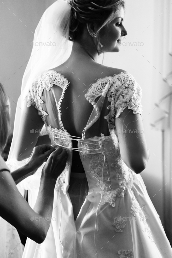 luxury gorgeous blonde bride getting dressed in the morning with ...