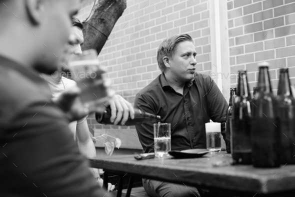 Group of men hanging out and relaxing together in the backyard Stock ...