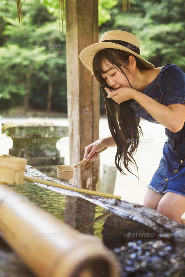 Young woman using bamboo water hand washing basins at shrine Stock ...