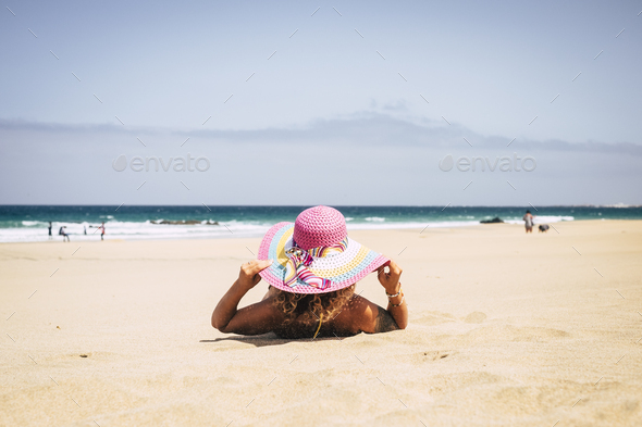 rear view of caucasian blonde woman lay down at the beach in summer ...