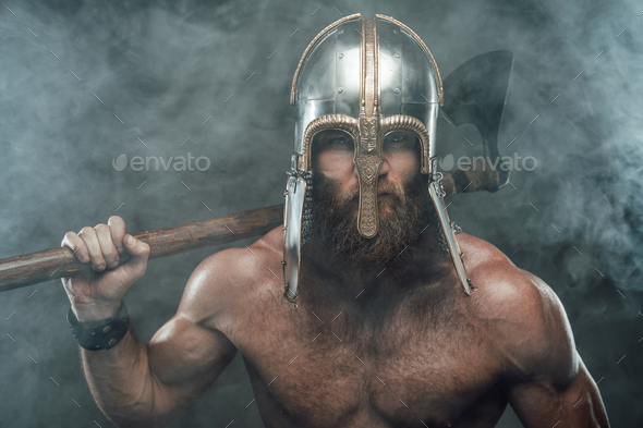 Viking posing in smoke with axe behind his back Stock Photo by fxquadro