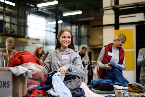 Volunteers sorting out donated clothes in community charity donation ...