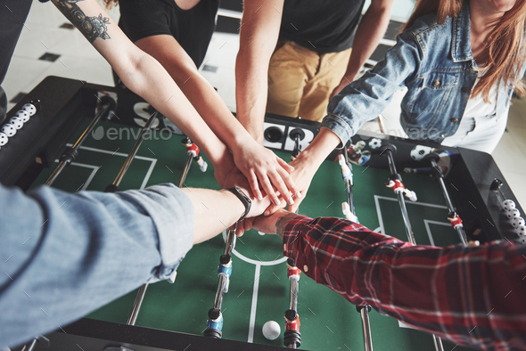 Friends together play board games, table football, have fun free time ...