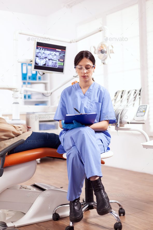 Dental assistant taking notes on clipboard in dentist clinic Stock ...