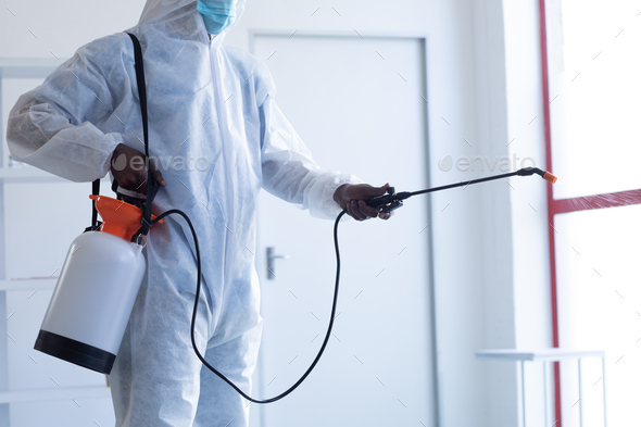 Health worker wearing protective clothes cleaning using disinfectant ...