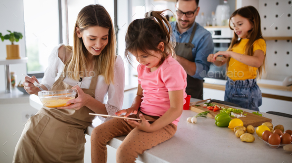 Overjoyed young family with kids having fun, cooking at home together ...