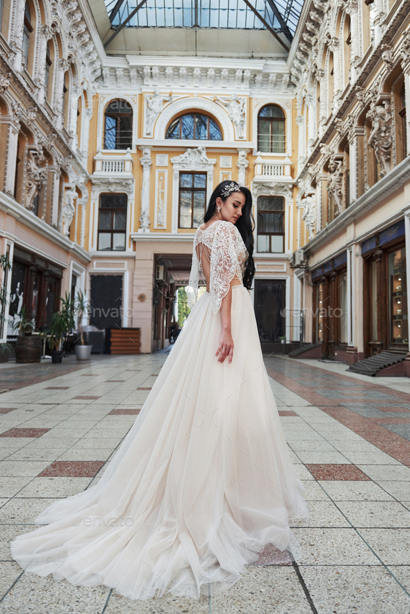 Beautiful, elegant bride with a perfect wedding dress, poses around ...