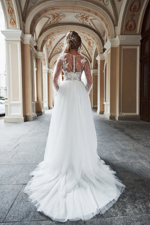 Beautiful, elegant bride with a perfect wedding dress, poses around ...