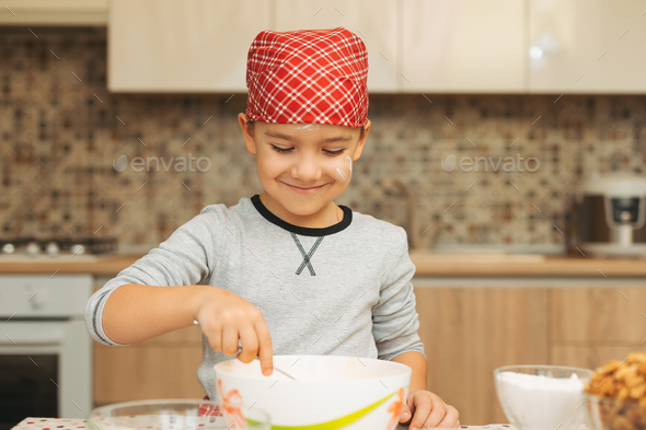 Boy is cooking in a luminous kitchen mixing ingredients Stock Photo by ...