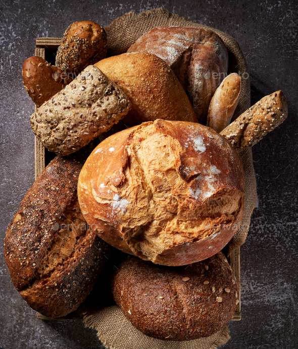 Different Types of Bread on dark background. Stock Photo by milabond