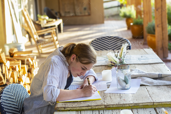 Teenage girl writing outside on terrace at sunset. Stock Photo by Mint ...