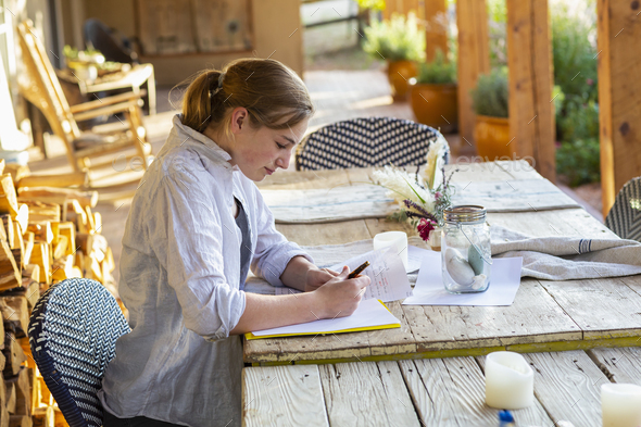 Teenage girl writing outside on terrace at sunset. Stock Photo by Mint ...