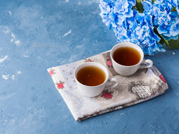 Cup of tea on blue background with flowers Stock Photo by tenkende