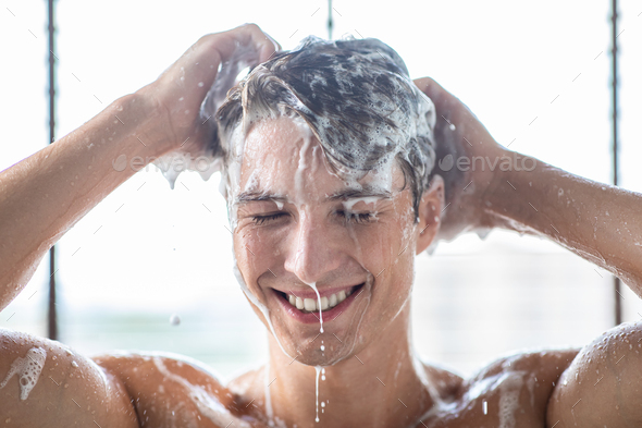 Handsome young male model washing hair with shampoo Stock Photo by ...