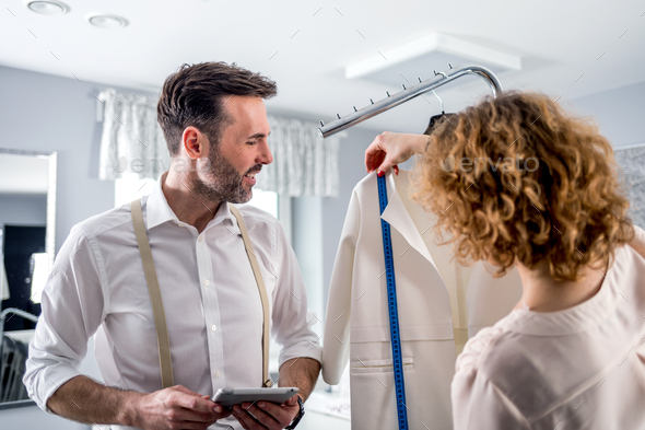 Professional tailors during work talking about project in fashion ...