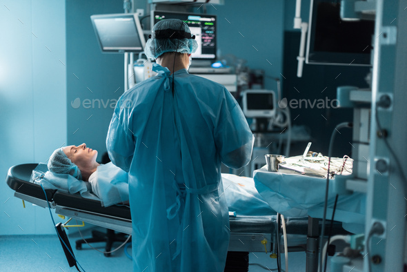 back view of surgeon operating patient in operating room Stock Photo by ...