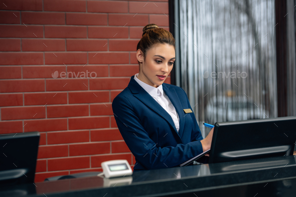 young hotel receptionist using computer at workplace Stock Photo by ...