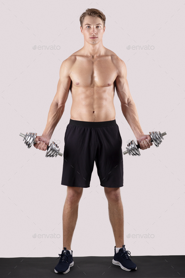 Full length portrait of motivated millennial bodybuilder exercising ...