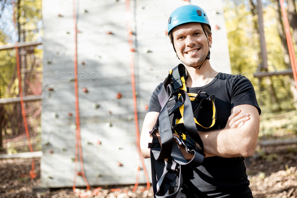 Well equipped man near the climbing wall outdoors Stock Photo by RossHelen