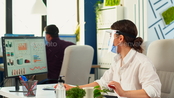 Businesspeople working wearing protection face masks in office room ...