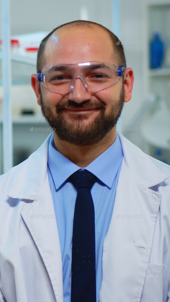 Portrait of scientist man smiling at camera sitting in modern ...